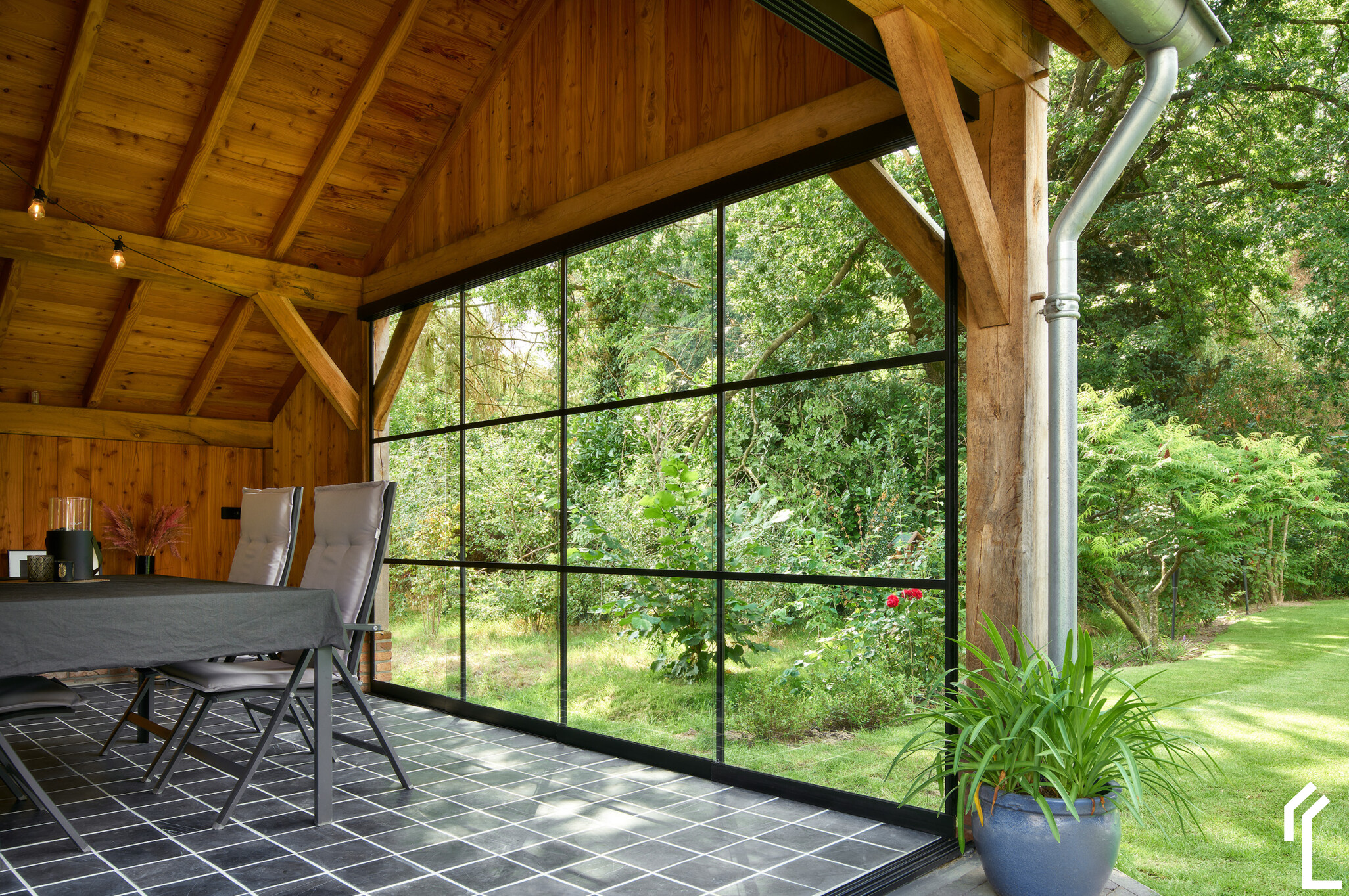 Droomtuin: een stijlvolle overkapping met zwarte schuifdeuren | Solundo